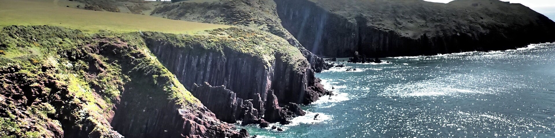 Paisagem costeira com falésias e mar azul límpido.