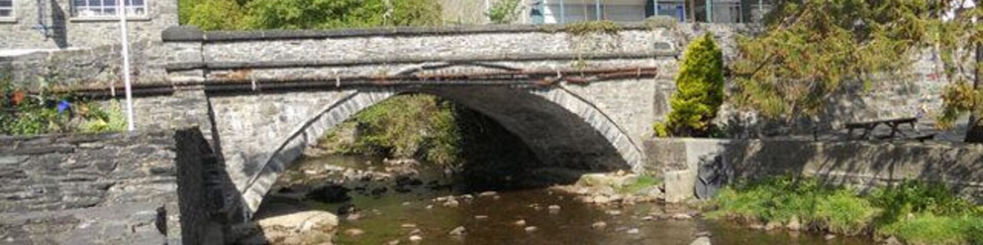 Uma ponte de pedra sobre um rio, com edifícios de ambos os lados.