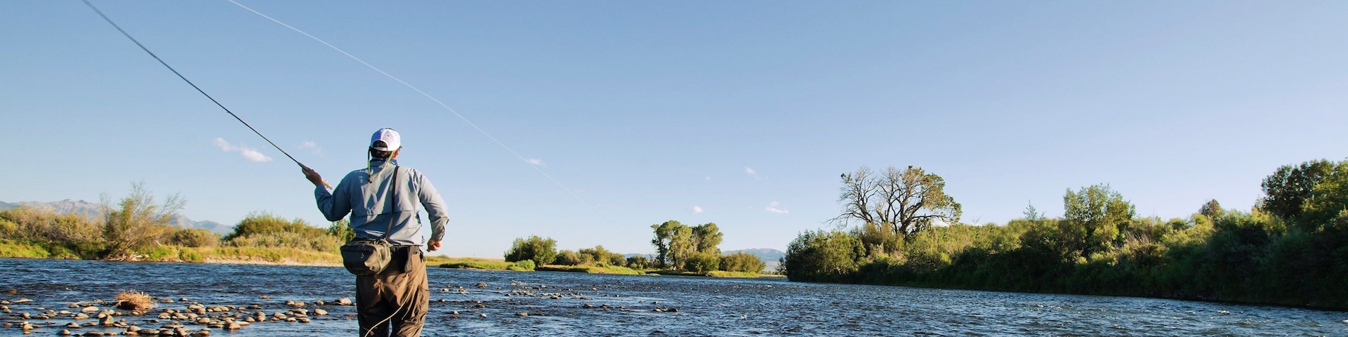 Ennis que inclui um rio ou córrego e pesca assim como um homem sozinho