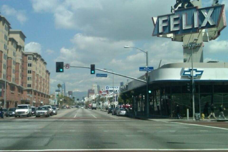 Uma rua com uma placa Felix, edifícios e um semáforo.