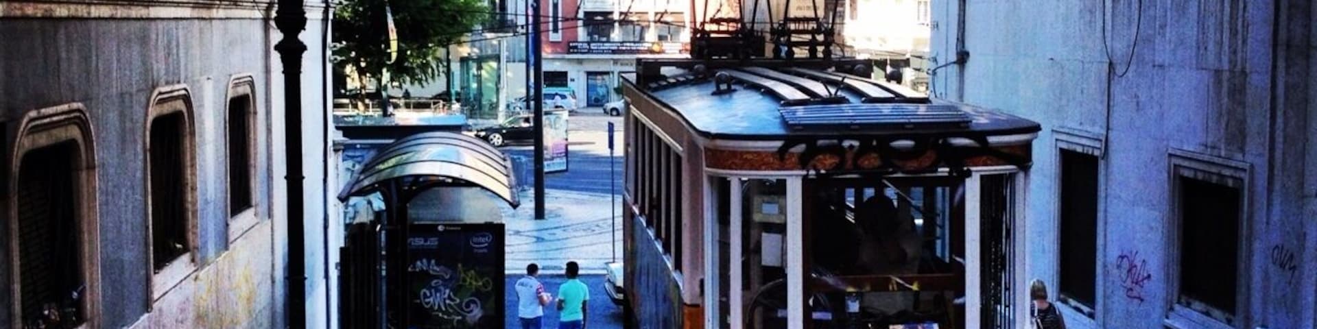 Um elétrico antigo numa rua de calçada em área urbana histórica.