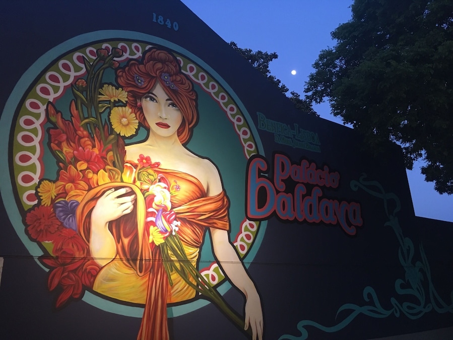 Um mural retrata uma mulher segurando flores, com o texto 'Palacio Baldorioty de Carvalho' e o ano '1840'.