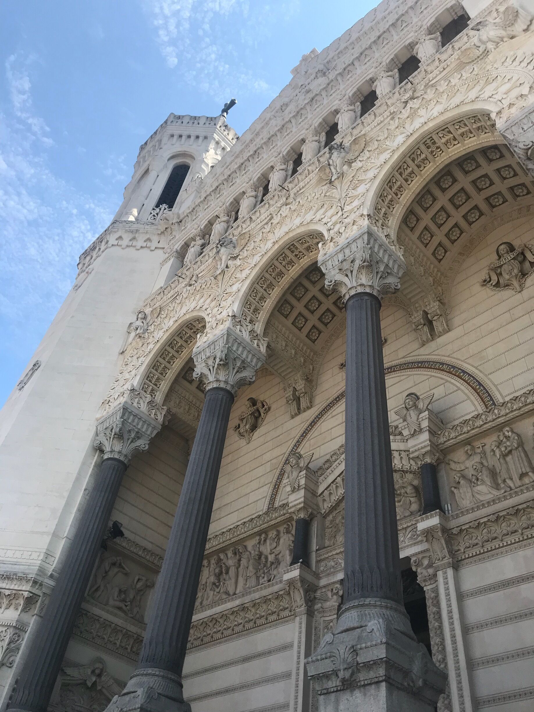 Um edifício imponente com esculturas elaboradas, colunas grandes e estátuas.