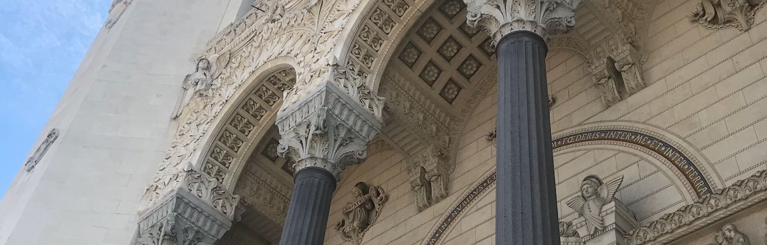 Um edifício imponente com esculturas elaboradas, colunas grandes e estátuas.