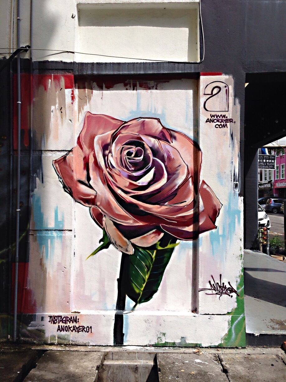 Um mural de uma rosa em uma parede de edifício.