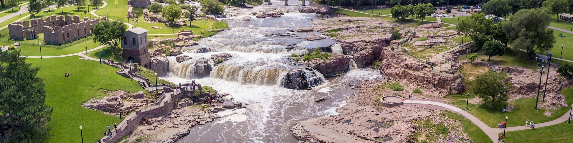 Uma cascata, um rio e ruínas de uma construção antiga.