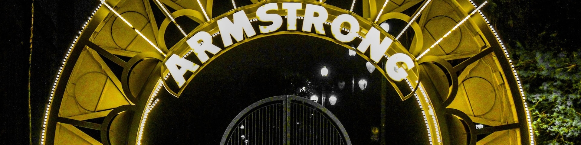 Um grande arco iluminado com a palavra "ARMSTRONG" no centro.