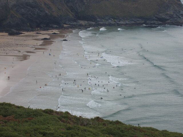 Uma praia costeira com ondas e pessoas.