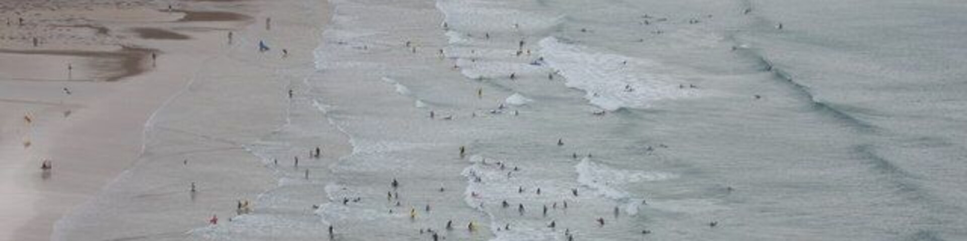 Uma praia costeira com ondas e pessoas.