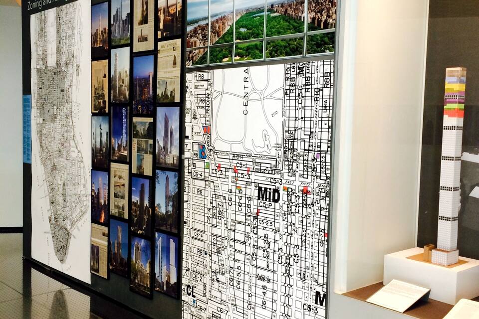Paisagem urbana com um mapa grande, fotografias de edifícios e uma torre de LEGO.