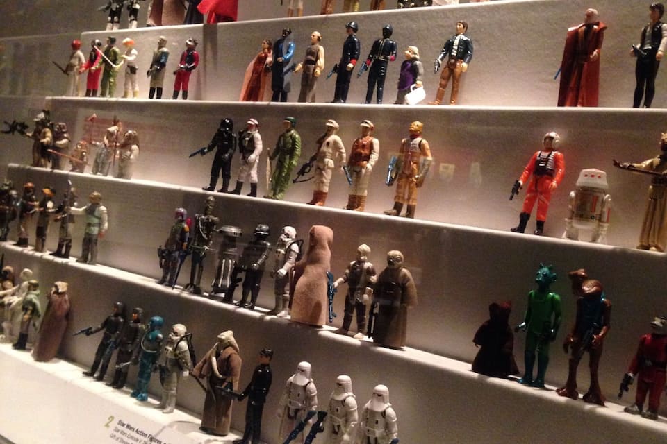 Exposição de figuras de ação de Star Wars organizadas em prateleiras.
