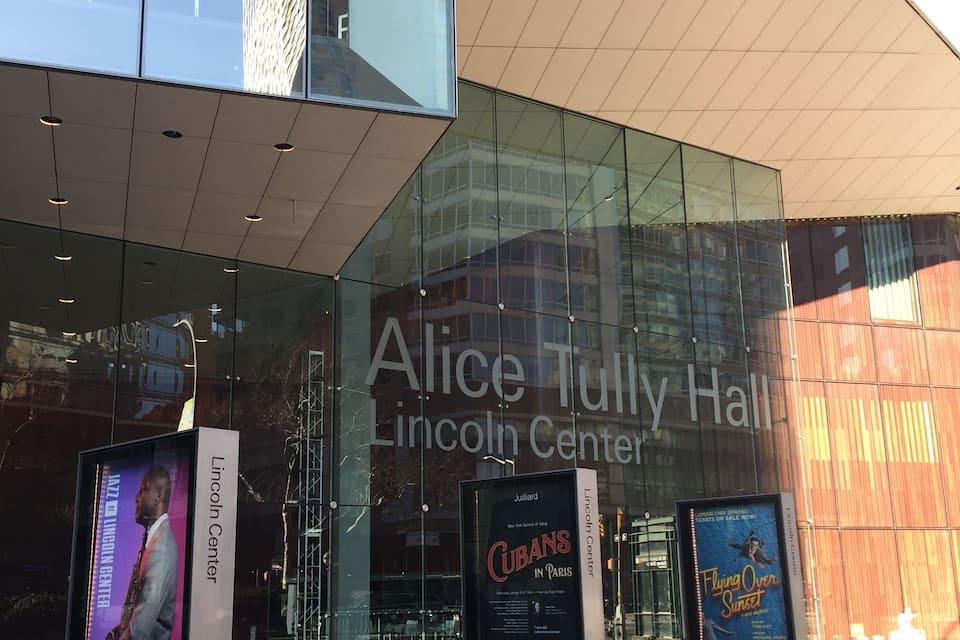 O Alice Tully Hall no Lincoln Center com anúncios para 'CUBANS IN PARIS' e 'Flying Over Sunset'.