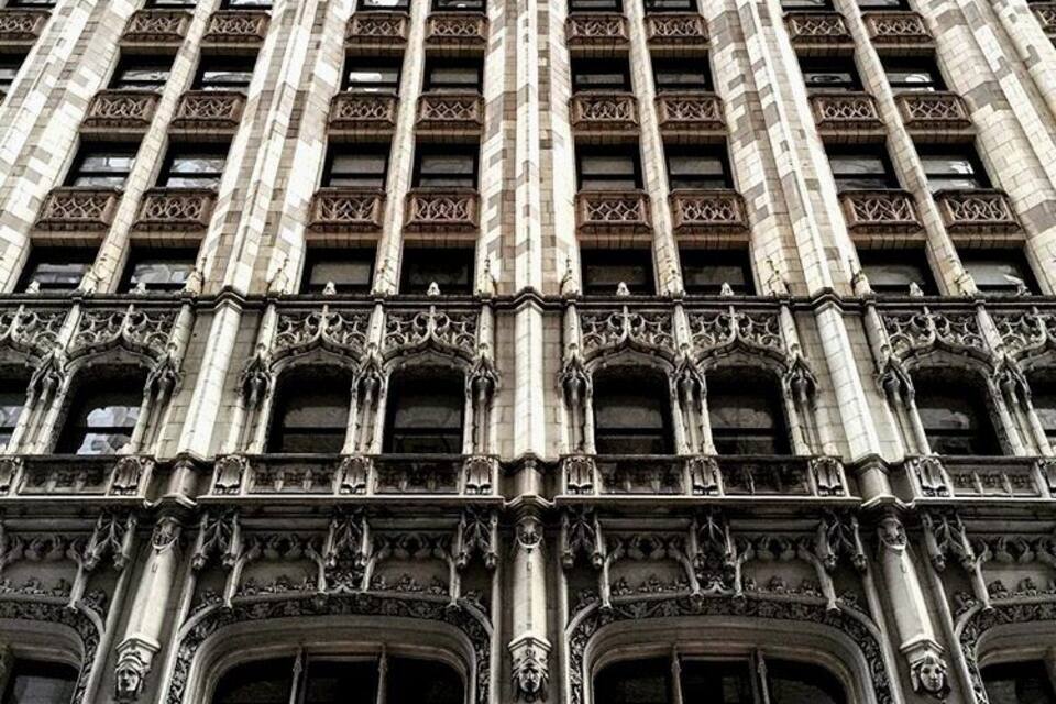 Um edifício alto com detalhes arquitetônicos elaborados e várias janelas.