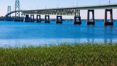 Uma grande ponte de aço que atravessa um rio de águas azul-claras.