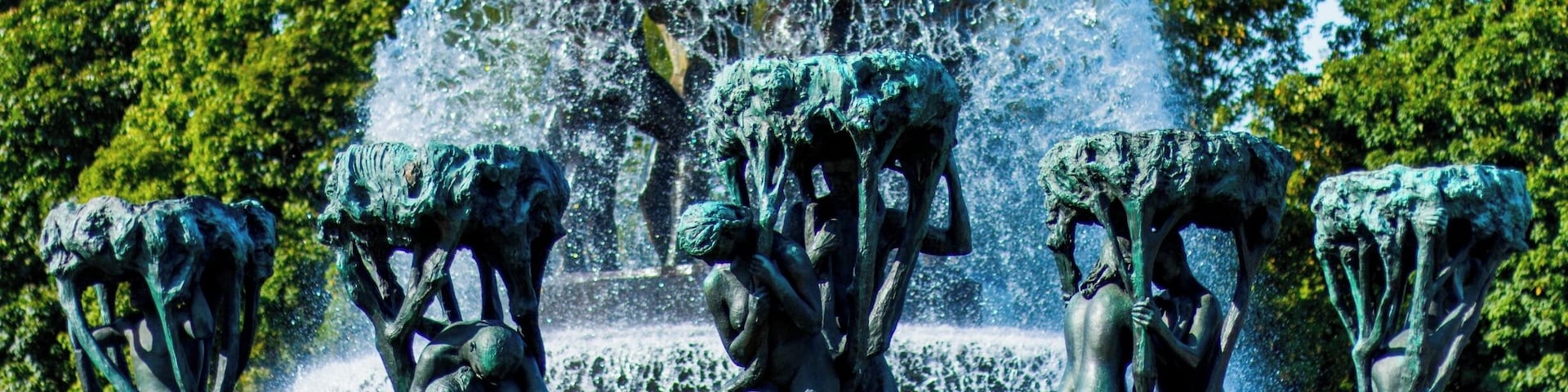 Uma fonte com várias estátuas e pássaros empoleirados.