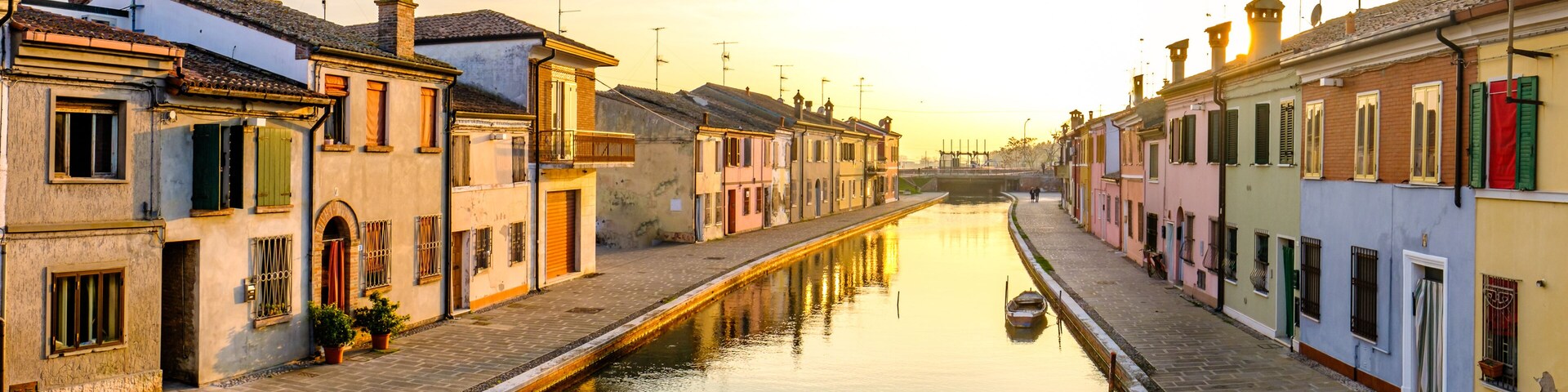 Um canal ladeado por edifícios históricos com um barco atracado à direita.
