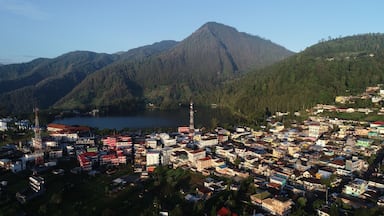 Uma cidade com casas coloridas, um lago e uma montanha ao fundo.
