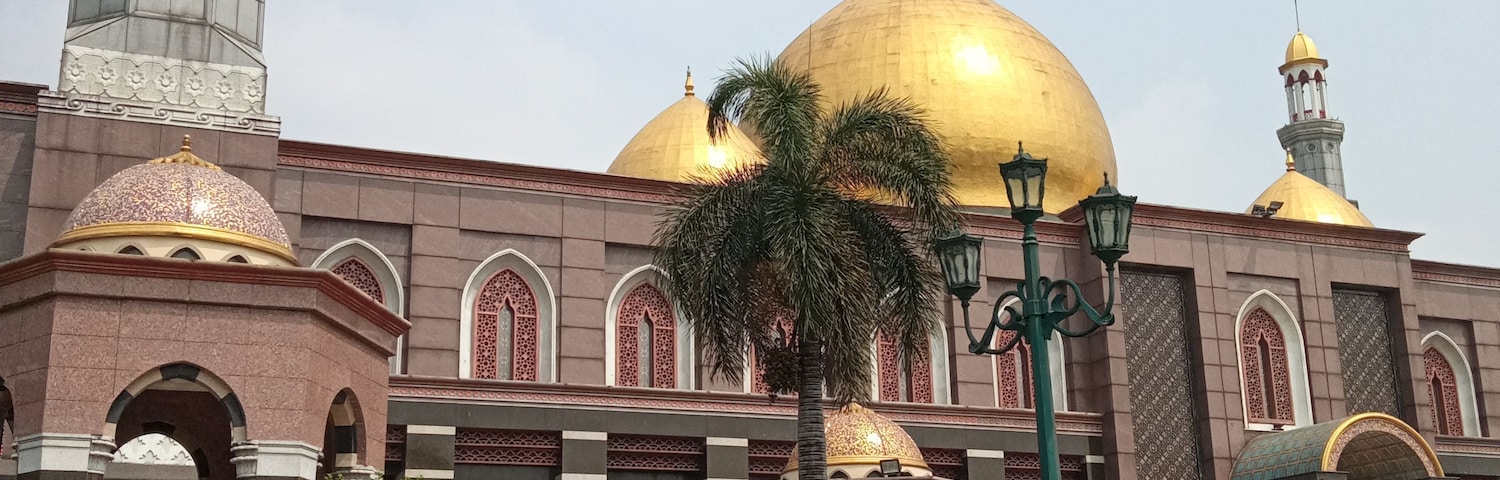Uma mesquita com um minarete alto e cúpulas douradas.