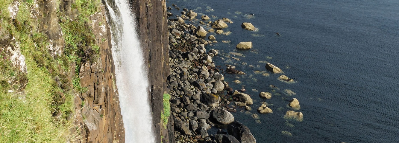 The waterfall from Loch Mealt falls 55 metres to the sea. Behind is Kilt Rock, 90 metres tall, so-called because the combination of basalt columns upon a sandstone base resembles a kilt.