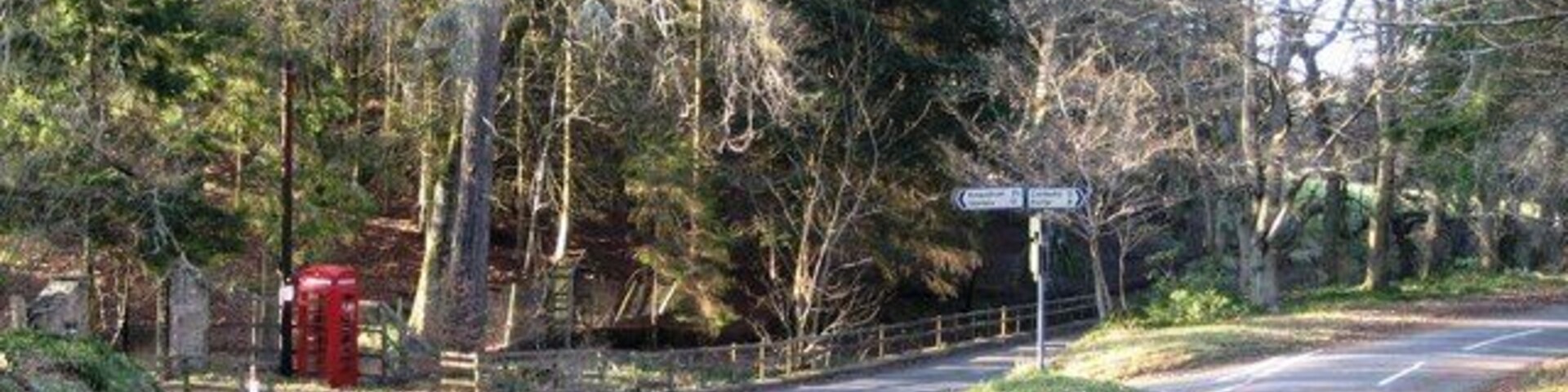 Crossroads at Pearsie Junction on two of the many small roads at the foot of Glen Prosen and Glen Clova. An 'old style' red phone box stands at one corner.