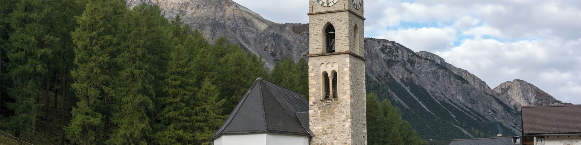 Biosfera Val Müstair - Kirche von Tschierv, dahinter Piz Daint