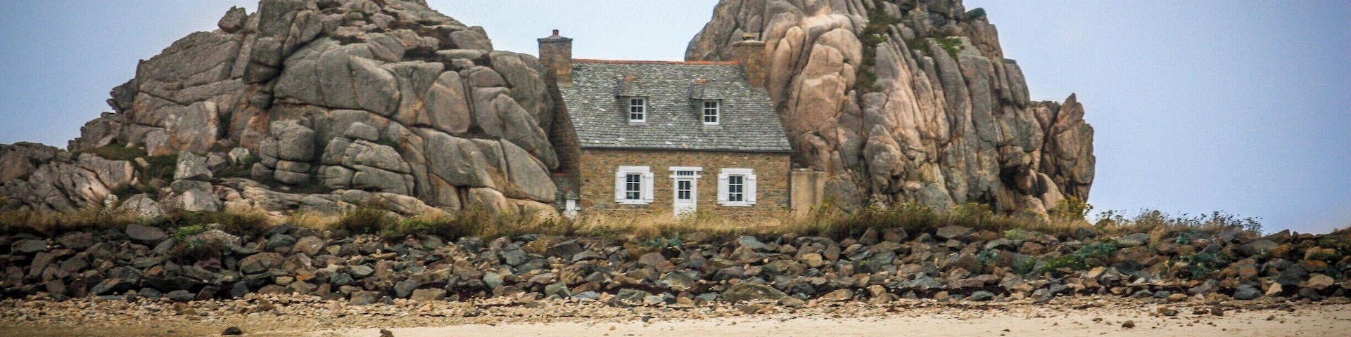 Small house built in between huge rocks on the Brittany coast near Plougrescant.