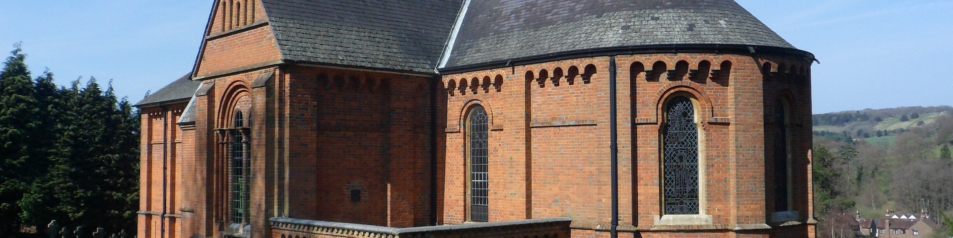 Uma igreja de tijolos com uma torre de sino e uma cúpula.