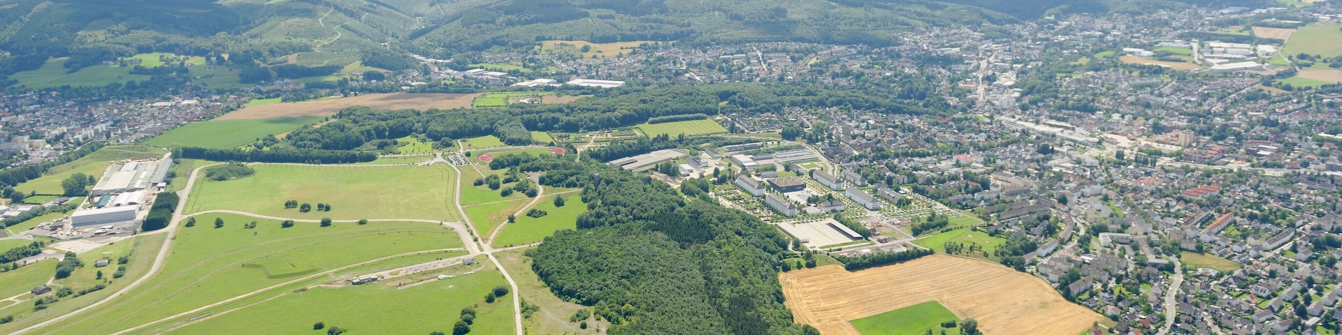 Luftaufnahme: Links Deilinghofen, westlicher Bereich des Naturerlebnisgebiet Hemer-Apricke der NRW-Stiftung mit ehemaligen Panzerstraßen des Standorttruppenübungsplatzes, dahinter Hemer mit Sauerlandpark und ehemasliger Blücher Kaserne in der Bildmitte