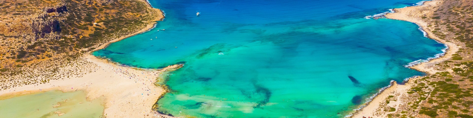 Paisagem costeira com águas turquesa cristalinas, praias de areia e falésias rochosas.