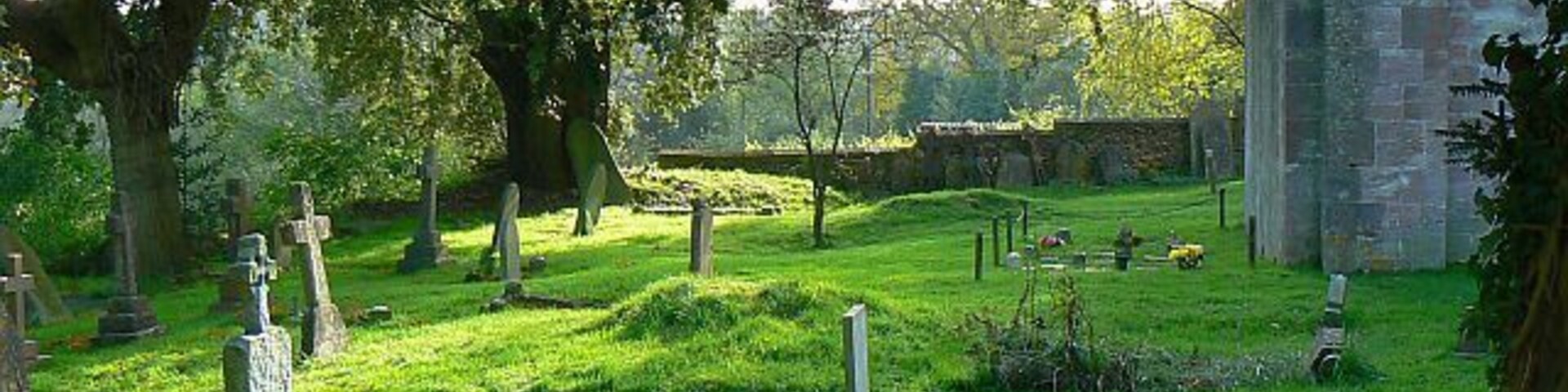 Churchyard and graves, Church of St John the Baptist, France Lynch, Chalford The east end of the church is at the right. The church is early Victorian.