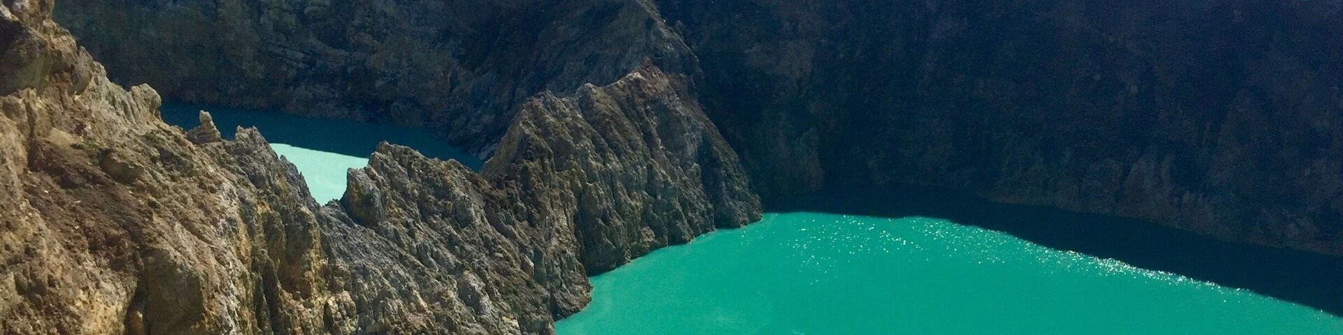 Um lago azul profundo, rodeado por penhascos íngremes e rochosos.