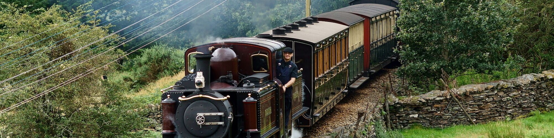 Ffestiniog Railway locomotive Merddin Emrys with a train along the line.