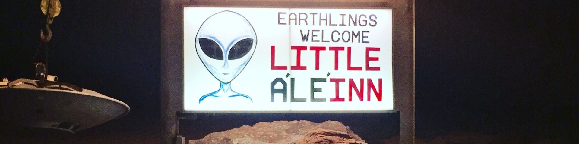 Um letreiro de neon para um restaurante, bar e motel com ilustração de um alienígena.