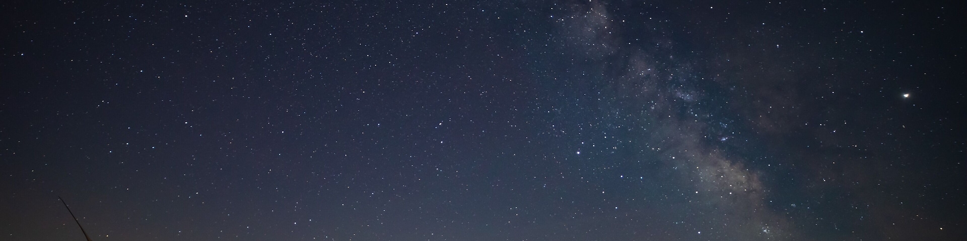 Milky Way photographed on clear sky night near a wind farm