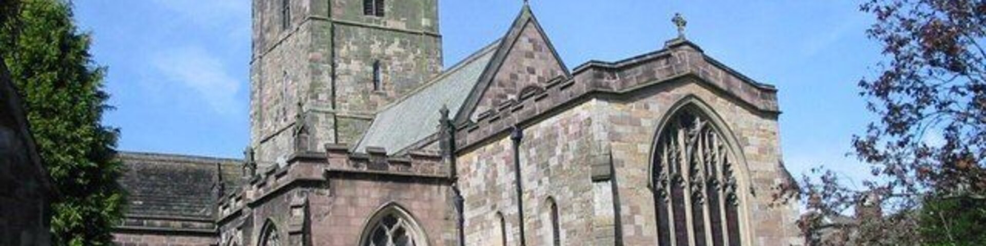 Uma igreja histórica com uma torre alta e janelas em arco.