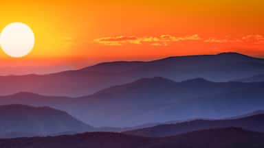 Uma cordilheira com o sol se pondo.