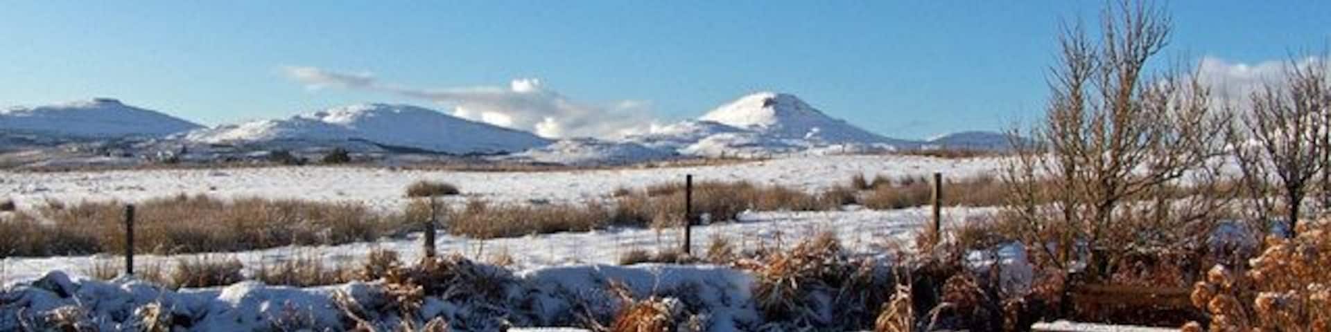Garden and view, January 2010 A covering of snow and bright winter sunshine. A long shadow is being cast from the birdbath in my garden in Roskhill near Dunvegan. The view is south west, with Healabhal Bheag just right of centre and Beinn na Boineid to the far left. (Just for the record, this is my 3,999th Geograph submission).