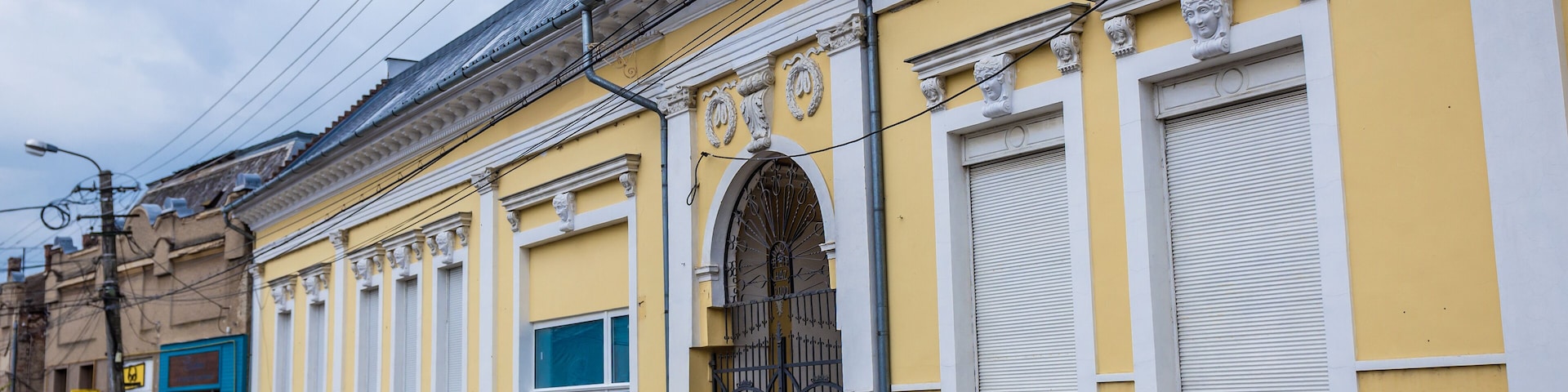 Um edifício amarelo com porta azul e portão preto.