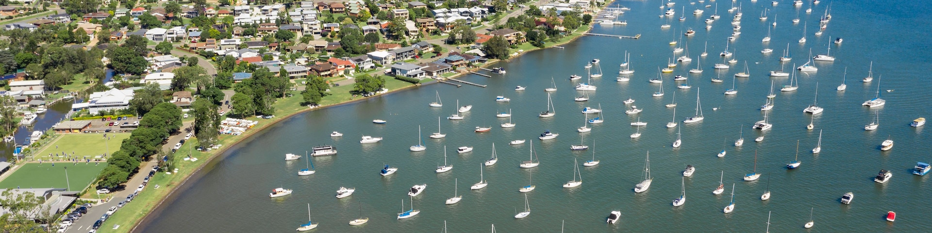 Uma vila costeira com vários barcos à vela ancorados ao longo da orla.