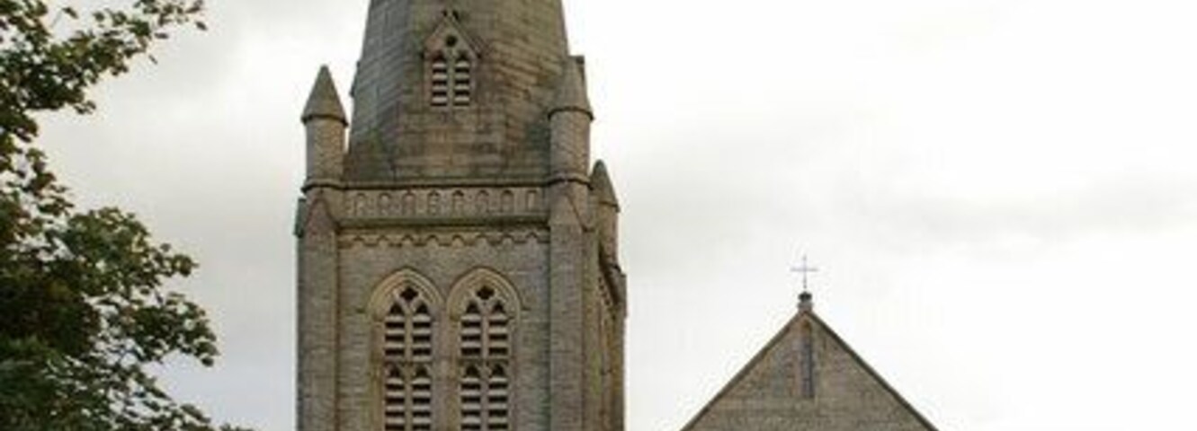 Uma igreja com um campanário alto e grandes janelas em arco.