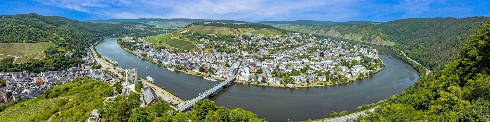 Um rio serpenteia por uma cidade rodeada por colinas.