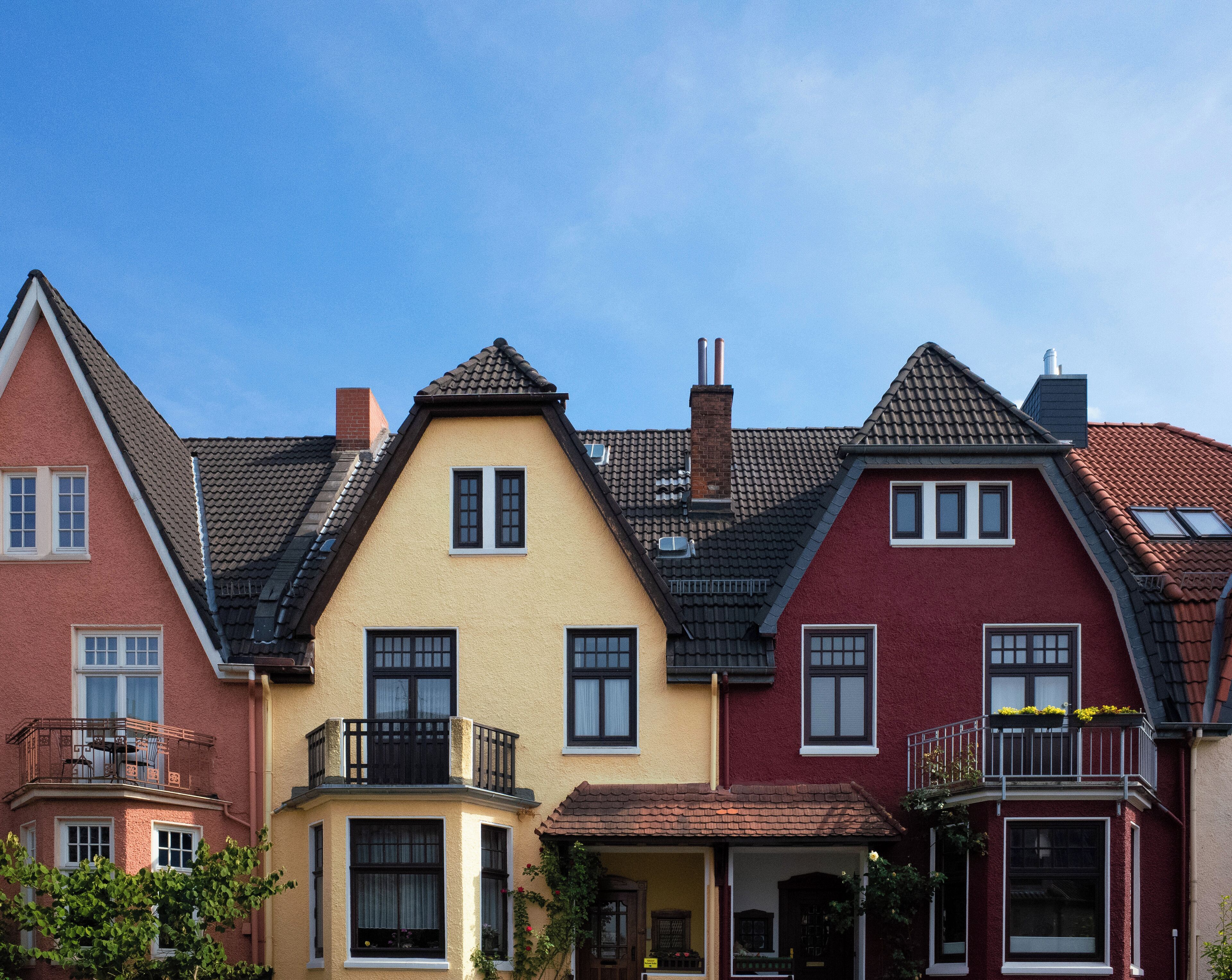 Uma fileira de casas coloridas com estilos arquitetônicos distintos e um céu azul límpido.