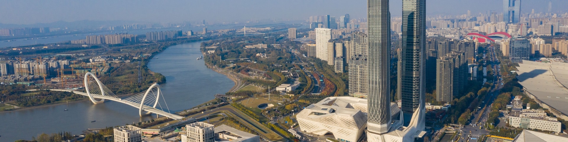 Paisagem urbana com arranha-céus modernos, um rio e uma ponte característica.