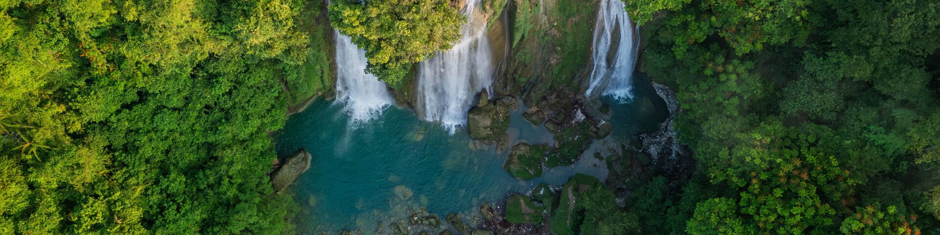 Uma cascata cercada por uma floresta verde densa.
