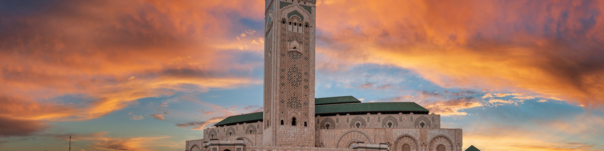 Uma mesquita imponente com um minarete alto, trabalhos em azulejos detalhados e um pátio espaçoso.