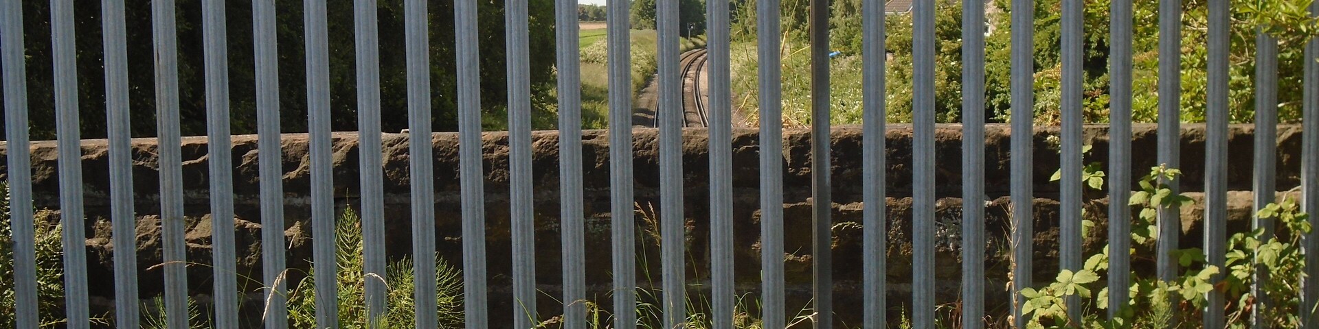 The stone parapet is low, hence the fence.