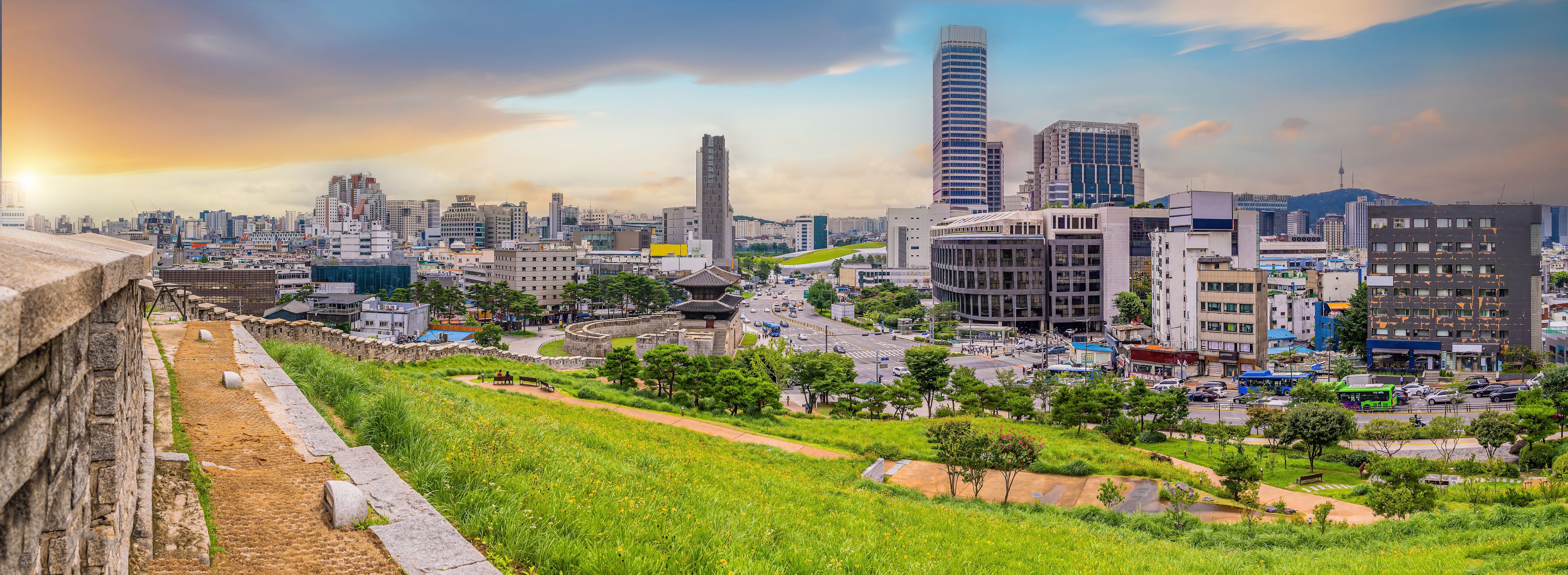Paisagem urbana com edifícios modernos, um pagode tradicional e um rio.