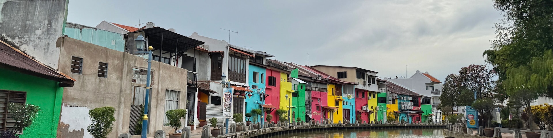 Um canal com edifícios coloridos de um lado e uma ponte sobre ele.