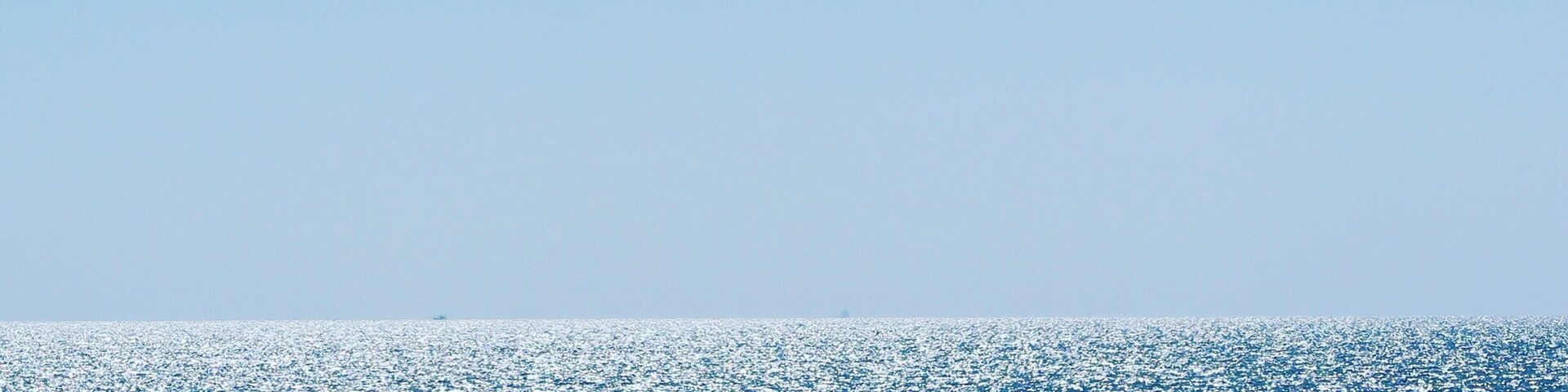Uma vasta extensão de oceano com céu claro.