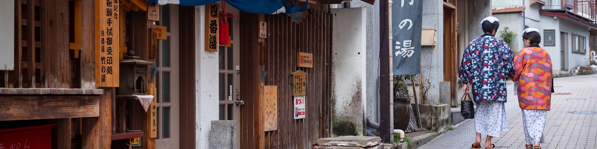 Edifício tradicional japonês com detalhes em madeira e sinalização em japonês.